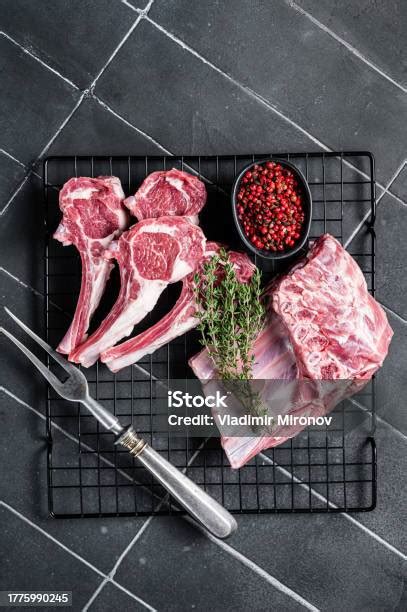 신선한 생 양고기 고기는 향신료와 허브를 곁들인 식탁에서 스테이크를 자른다 검은 배경입니다 상위 뷰 0명에 대한 스톡 사진 및 기타 이미지 Istock