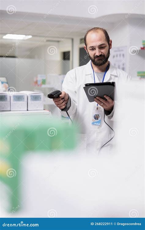 Pharmacist Checking Medication List On Tablet Computer While Scanning