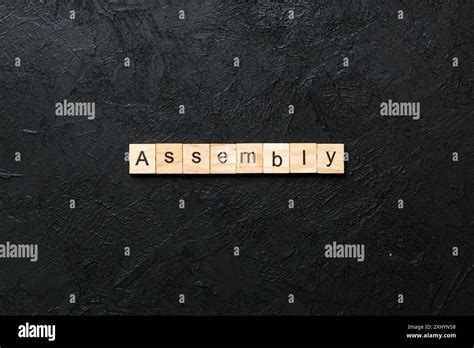 Assembly Word Written On Wood Block Assembly Text On Cement Table For Your Desing Concept Assembly Word Written On Wood Block Assembly Text On Cement Table For Your Desing Concept