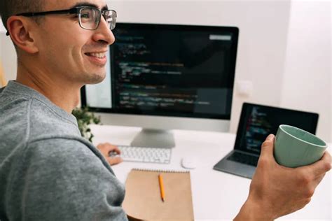 Programmer Working Behind The Desk Googling And Coding At The Same