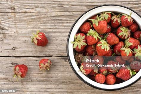 화창한 날에 소박한 나무 배경에 갓 딴 잘 익은 빨간 딸기로 가득 찬 빈티지 화이트 에나멜 그릇 비타민이 풍부한 여름 열매 건강한 영양 개념 가득 찬에 대한 스톡 사진 및