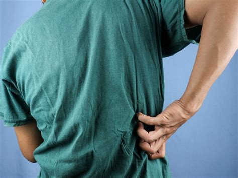 Premium Photo Asian Young Man Scratching His Back Isolated Blue Background
