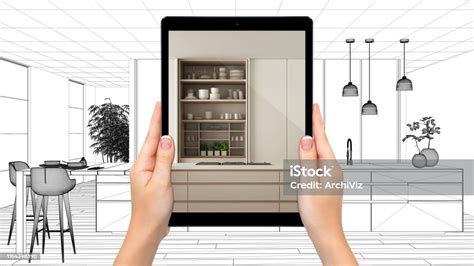 손은 현대 흰색과 나무 부엌을 보여주는 태블릿을 들고 청사진 Cad 스케치 배경 증강 현실 개념 가구 및 인테리어 디자인 제품을