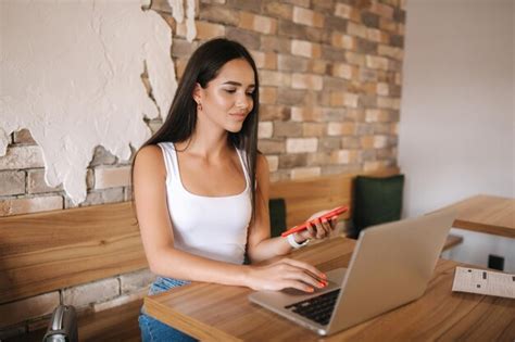 Premium Photo Attractive Girl Working On Laptop In Cafe Beautiful