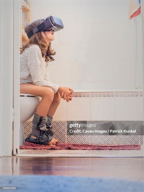 Girl Sitting On Toilet Bowl And Wearing Virtual Reality Glasses High