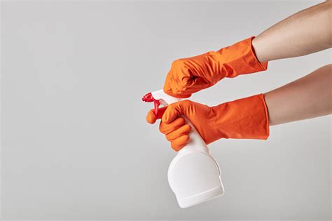 클리너는 오렌지 고무 세척 장갑을 착용하고 흰색 빈 청소 스프레이를 들고 스튜디오 샷 복사 공간을 복사합니다 최소한의 컨셉을 청소하고 세척합니다 가사 집안일에 대한 스톡