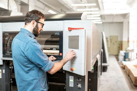 worker following a printing process on the offset machine at the