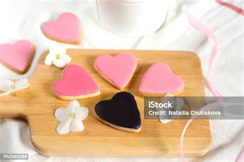 화이트 바이올렛 꽃과 새틴 리본 상단 보기에 부드럽게 핑크 하트 비스킷 쿠키와 예쁜 소녀의 편평한 누워 스타일 2 월 14 일 발렌타인 데이 선물 간식 꽃 식물에 대한 스톡