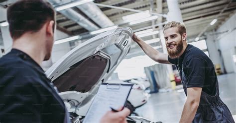 제복을 입은 두 명의 잘 생긴 기계공이 자동차 서비스에서 일하고 있습니다 자동차 수리 및 유지 보수 사진 Unsplash의 자동차 검사 이미지