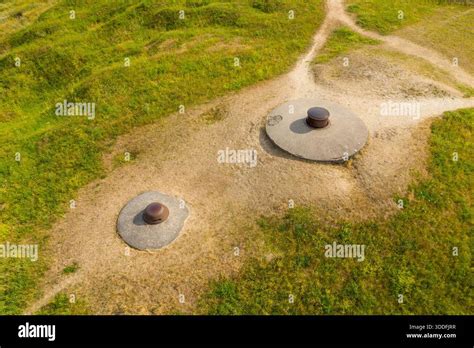 Aerial Close Up Of Two Historic Concrete Turrets Emerging From Cratered