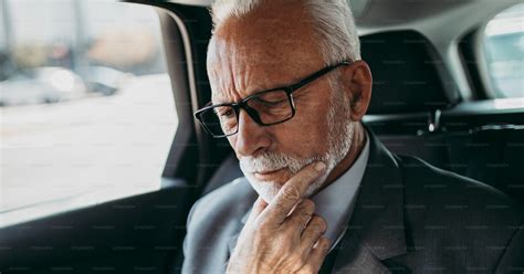 고급 자동차의 뒷좌석에 앉아있는 잘 생긴 고위 사업가 그는 노트북을 사용하고 감정적으로 반응합니다 기업 비즈니스 개념의 교통 사진 Unsplash의 세르비아 이미지