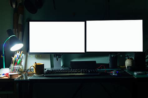 밤에 책상에 컴퓨터 모니터 2 개 사무실 책상에 모니터 스탠드에 보여주는 모바일 응용 프로그램 디자인과 개인용 컴퓨터 배경 사람들은 Cr의 칠판 벽에 작업 0명에 대한 스톡