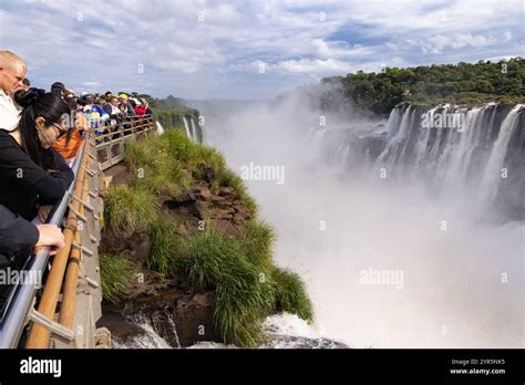 Iguazu Falls Tourism Tourists Looking At The Waterfall From A Walkway Iguazu Falls Argentina