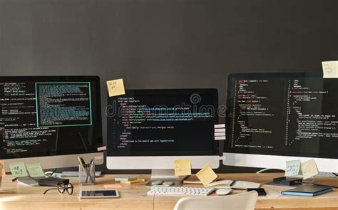Row Of Three Computer Monitors With Coded Data On Screens Standing On