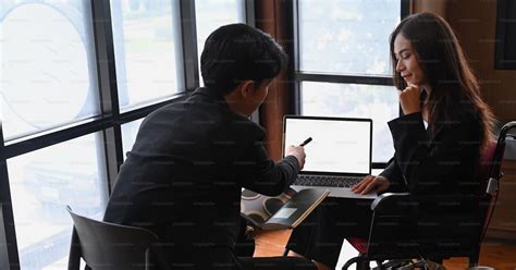 휠체어를 탄 장애인 여성이 동료와 함께 사무실에서 일하고 있다 사진 Unsplash의 태국 이미지