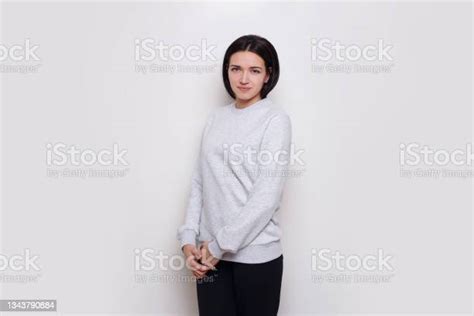 밝은 회색 스웨터에 쾌활한 젊은 여자 갈색 머리 흰색 배경에 고립 텍스트 공간입니다 25 29세에 대한 스톡 사진 및 기타