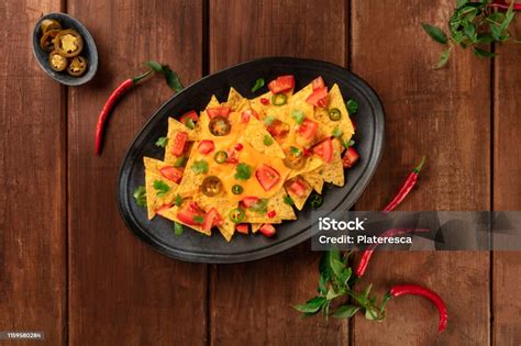 나초 멕시코 토르티야 칩 치즈 소스 칠리 할라피뇨 고추 토마토와 함께 위에서 촬영 그리고 실란트로 텍스트에 대한 장소와 어두운 소박한 나무 배경에 0명에 대한 스톡 사진 및