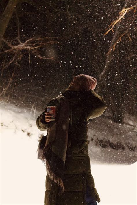 겨울 저녁에 눈이 내리는 것을 즐기는 사람 · 무료 스톡 사진