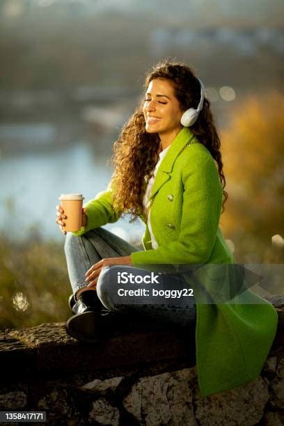 화창한 가을 날에 는 스마트 폰과 테이크 아웃 커피로 음악을 듣는 예쁜 젊은 여성 25 29세에 대한 스톡 사진 및 기타 이미지 25 29세 Brand Name