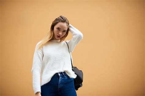 금발 머리와 매력적인 Hipster 여자의 반 길이 초상화 모의를 위한 공간과 스타일 청바지와 스웨터 입고 여성 패션 잡지 광고 텍스트에 대 한 복사 공간에 대 한 포즈