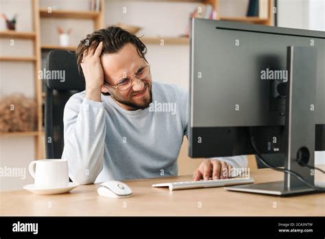 Image Of Unhappy Bearded Programmer Man Wearing Eyeglasses Working With