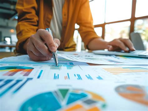 Close Up Of A Person Analyzing Financial Data And Reports With Charts