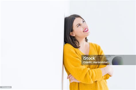 아름다운 갈색 머리 젊은 여자 미소 자신감과 밝은 위에 고립 된 흰색 배경 캐주얼 노란색 스웨터를 입고 갈색 머리에 대한 스톡