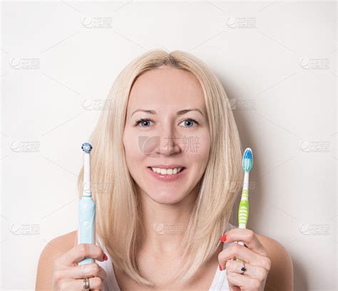 一个女孩在电动牙刷和普通牙刷之间做选择