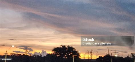 붉은색과 금색으로 물든 하늘 아래 길은 끝이 없어 보이며 황혼의 중심부로 이어집니다 석양의 노을이 아스팔트 위를 미끄러지듯 미끄러지고 길쭉한 그림자가 펼쳐져 빛과 어둠의