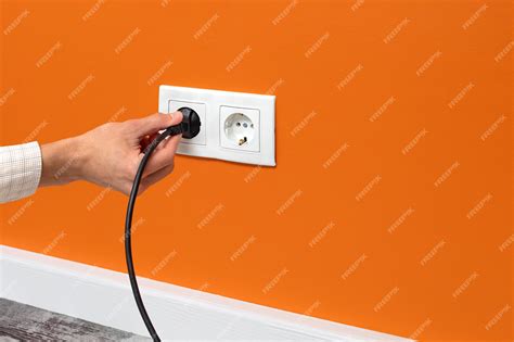 Premium Photo Man Unplugging Cord From A Electrical Outlet