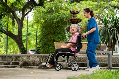 휠체어에 앉아있는 노인 여성과 젊은 간병인 또는 의료 종사자가 뒤에 서 있는 것은 보살핌 연민 및 지원 관계인 간병인과 노인의