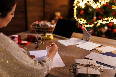 테이블에 앉아 사랑하는 사람들을 위해 크리스마스 편지와 카드를 쓰는 여자의 뒷모습 필기에 대한 스톡 사진 및 기타 이미지