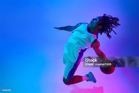 네온 불빛의 그라데이션 파란색 배경에 공을 들고 점프하는 프로 농구 선수의 역동적인 이미지 18 19세에 대한 스톡 사진 및 기타 이미지 18 19세 개념 건강한