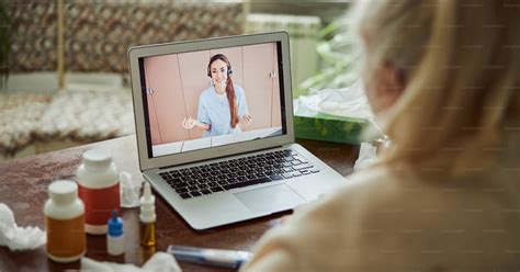 아픈 노인 여성이 노트북을 들고 테이블에 앉아 화상 통화를 통해 여성 의사와 이야기합니다 사진 Unsplash의 전달하다 이미지