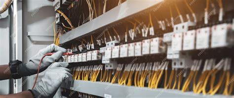 회로 차단기 터미널에서 전류 전압을 확인하는 Ac 전압계를 들고 있는 엔지니어 프리미엄 사진