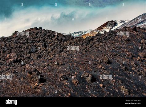 Lapilli And Black Earth The Snowy Slopes Of Etna In The Background A Striking Texture Contrast