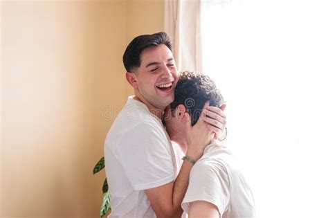 Young Gay Couple Laughing And Romantically Hugging And Touching Each