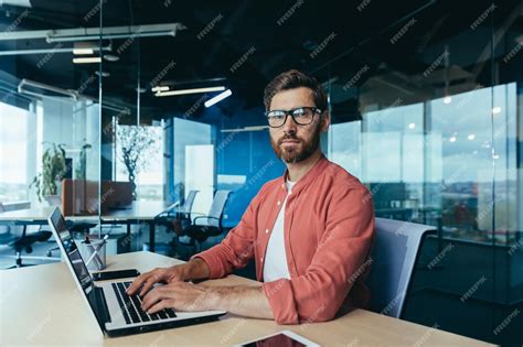 Premium Photo Portrait Of A Successful Programmer Inside The Office A Man With A Beard Glasses