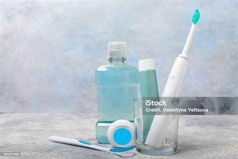 전자 초음파 칫솔 구강 세정제 치실 혀 클리너 및 치약이 질감 있는 배경에 있습니다 욕실에서 치과 치료 및 충치 예방을위한 항목