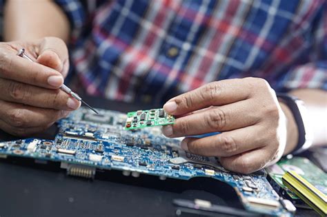 기술자는 솔더를 납땜하여 하드 디스크 내부를 수리합니다 집적 회로 데이터 하드웨어 전자 폐기물 및 기술의 개념 Cpu에 대한