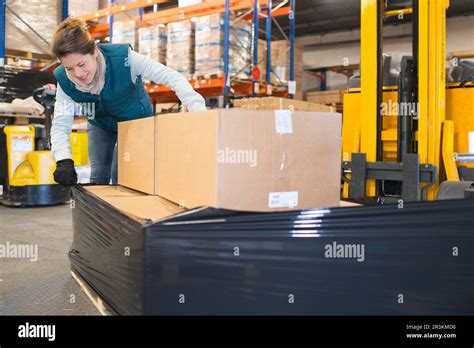 Female Worker Checking Shrink Wrap On Forklift Load Stock Photo Alamy