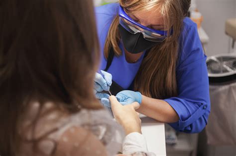 매니큐어 마스터는 미용실에서 손톱 귀여운 예쁜 젊은 여자를 만든다 20 24세에 대한 스톡 사진 및 기타 이미지 20 24세