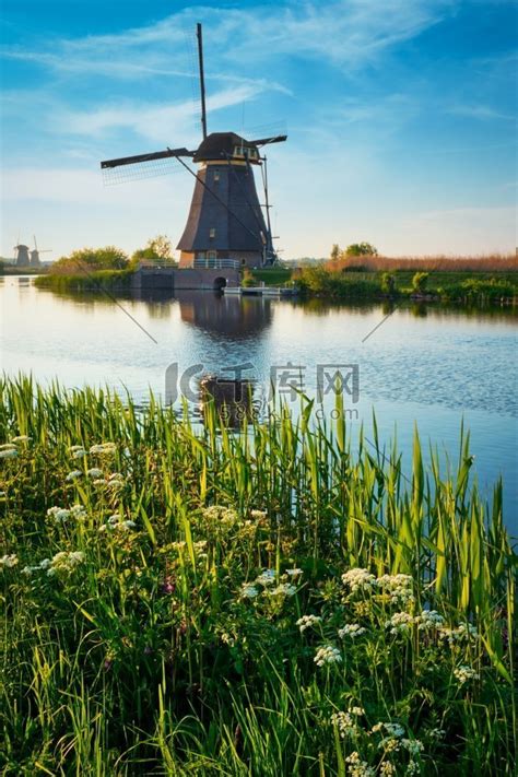 荷兰著名旅游胜地 Kinderdijk 的荷兰乡村景观与风车在日落时分与戏剧性的天空。高清摄影大图 千库网