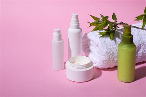 아름 다운 스파 및 미용 병 용기 녹색 초본 잎과 분홍색 배경에 수건으로 웰빙 구성 천연 미용 제품 컨셉 개념에 대한 스톡 사진