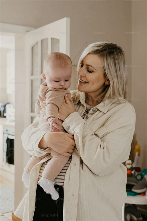 아기를 품에 안고 있는 여자 사진 Unsplash의 사람 이미지