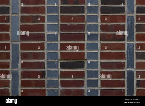 stacked red bricks with stripes of horizontal half bricks and vertical