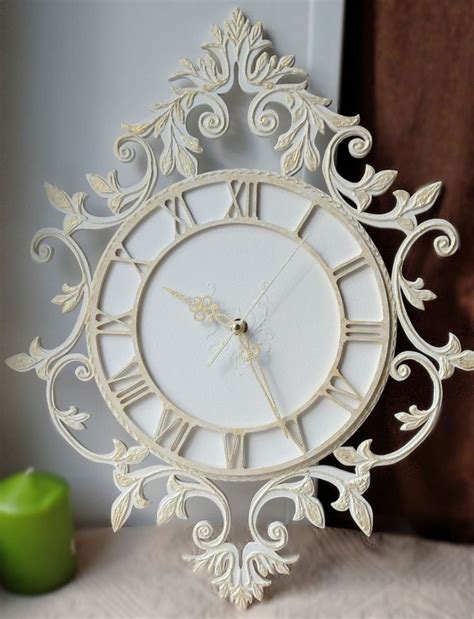 Small White Wall Clock With Gold Ornament And Roman Numerals In Vintage
