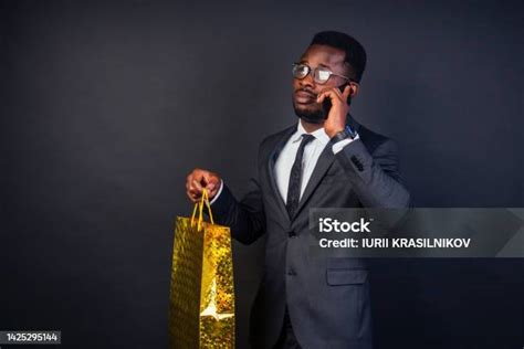 스튜디오에서 검은 배경에 쇼핑백을 들고 있는 아프리카계 미국인 남성 비즈니스 파트너블랙 프라이데이 세일 시즌 컨셉 20 24세에