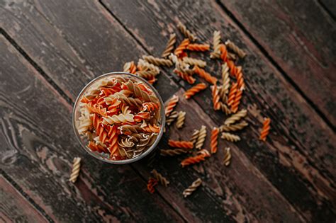 부엌에서 스마트 식품 저장 옵션 생 파스타와 주위에 흩어져 있는 오렌지 나선형 파스타를 저장하기위한 유리 항아리 곡초류에 대한 스톡 사진 및 기타 이미지 Istock