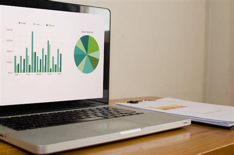 Premium Photo Close Up Of Laptop With Chart On Screen By Graph Papers At Office Desk